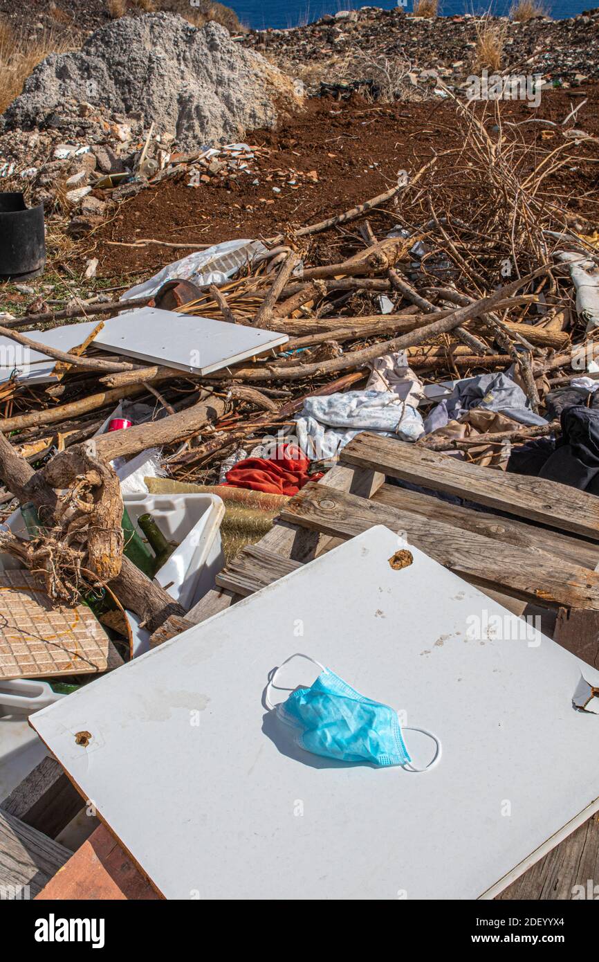 Surgical mask thrown away in the middle of the garbage. Vertical Stock ...