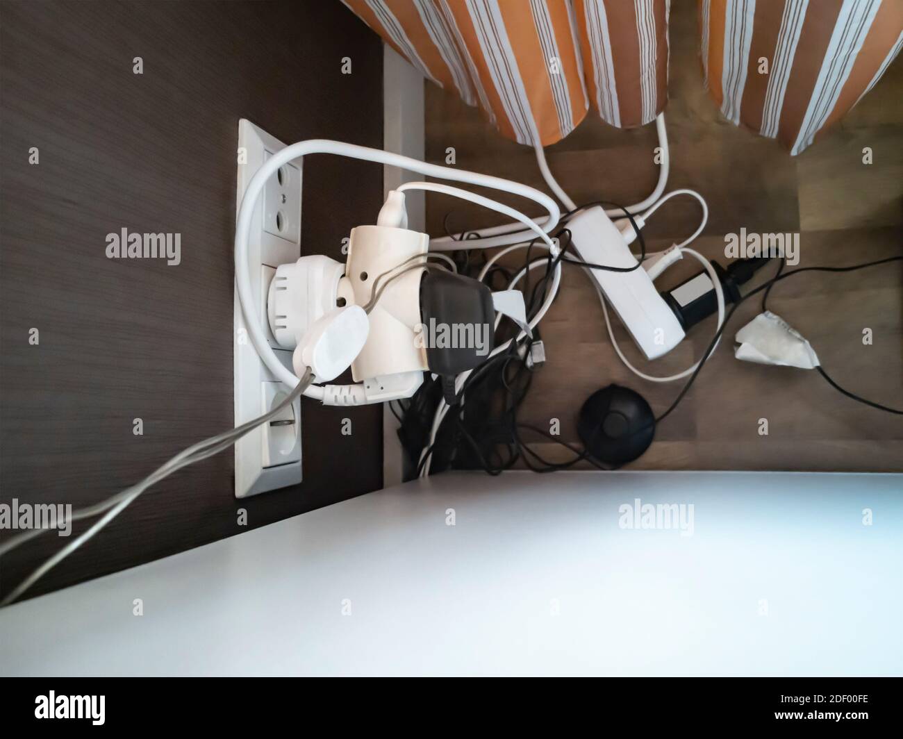 There is a power socket behind a cabinet. Many plugs and socket strips ...