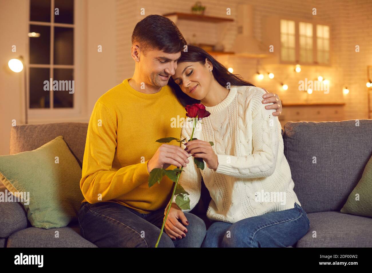 Young pretty smiling woman getting red rose as symbol of love from ...