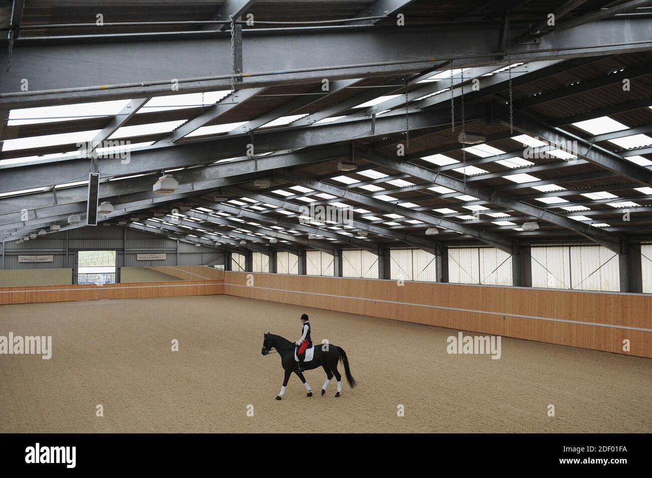 A Women riding her horse in an indoor Riding School Stock Photo - Alamy