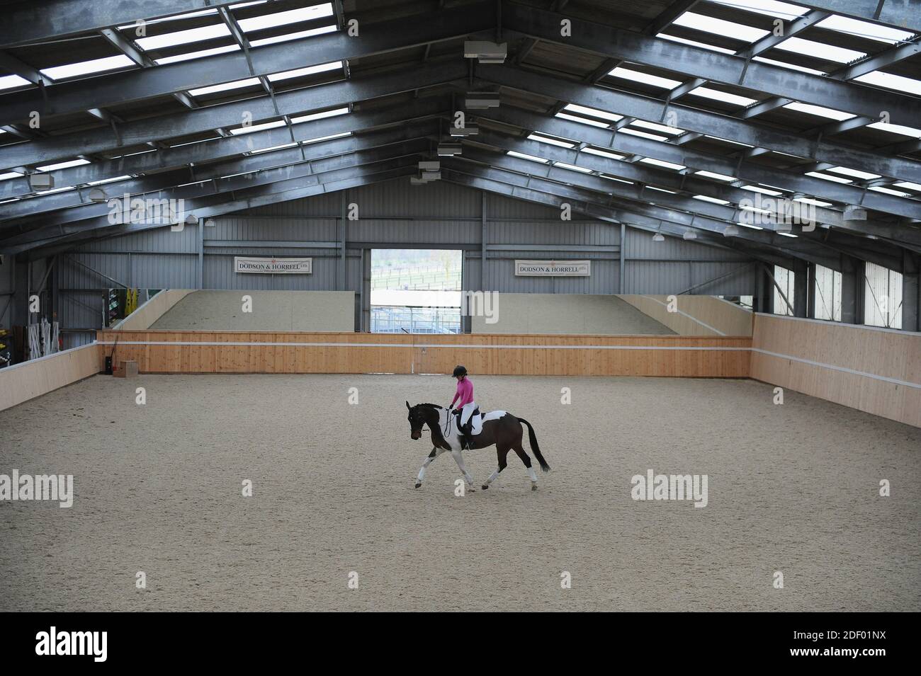 A Women riding her horse in an indoor Riding School Stock Photo - Alamy