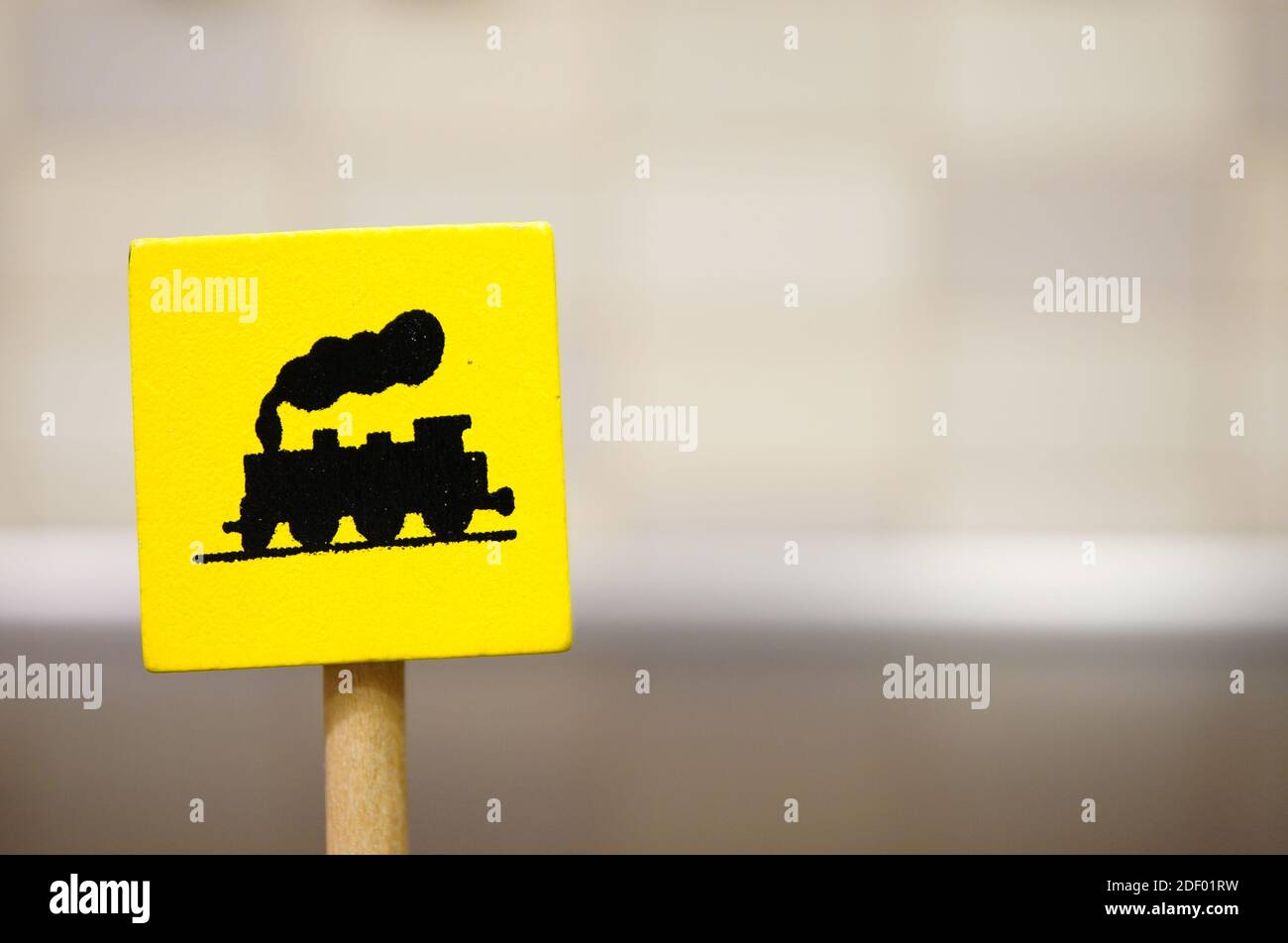 A yellow sign with train on it Stock Photo - Alamy