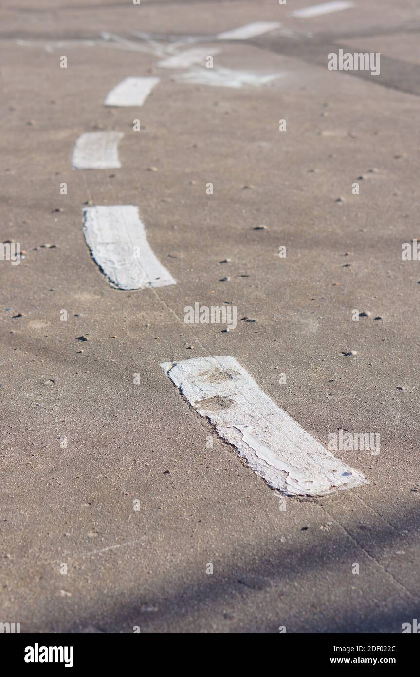 Broken white lines on an asphalt road indicating that you can change ...