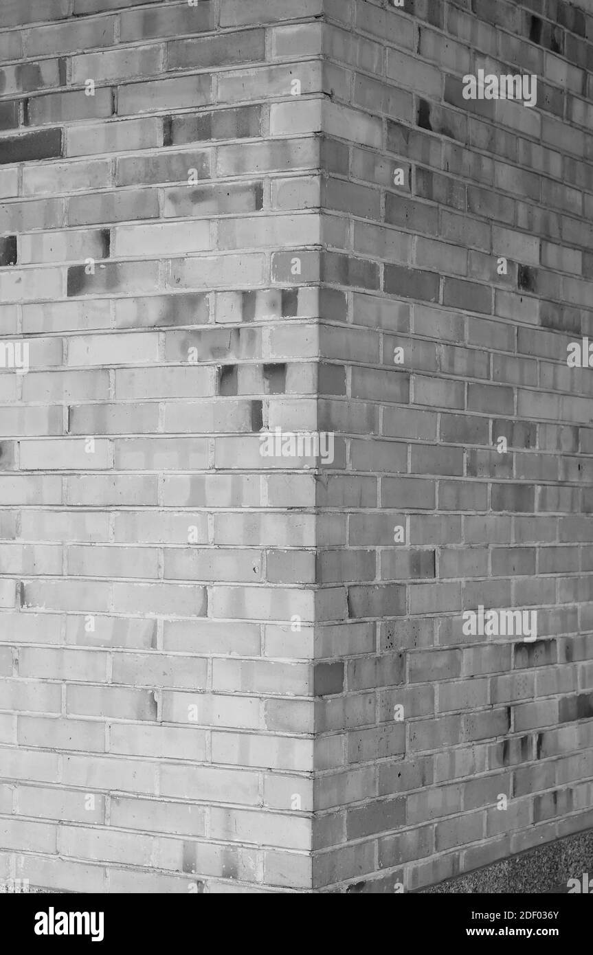 A vertical closeup shot of a brick building corner in grayscale for ...