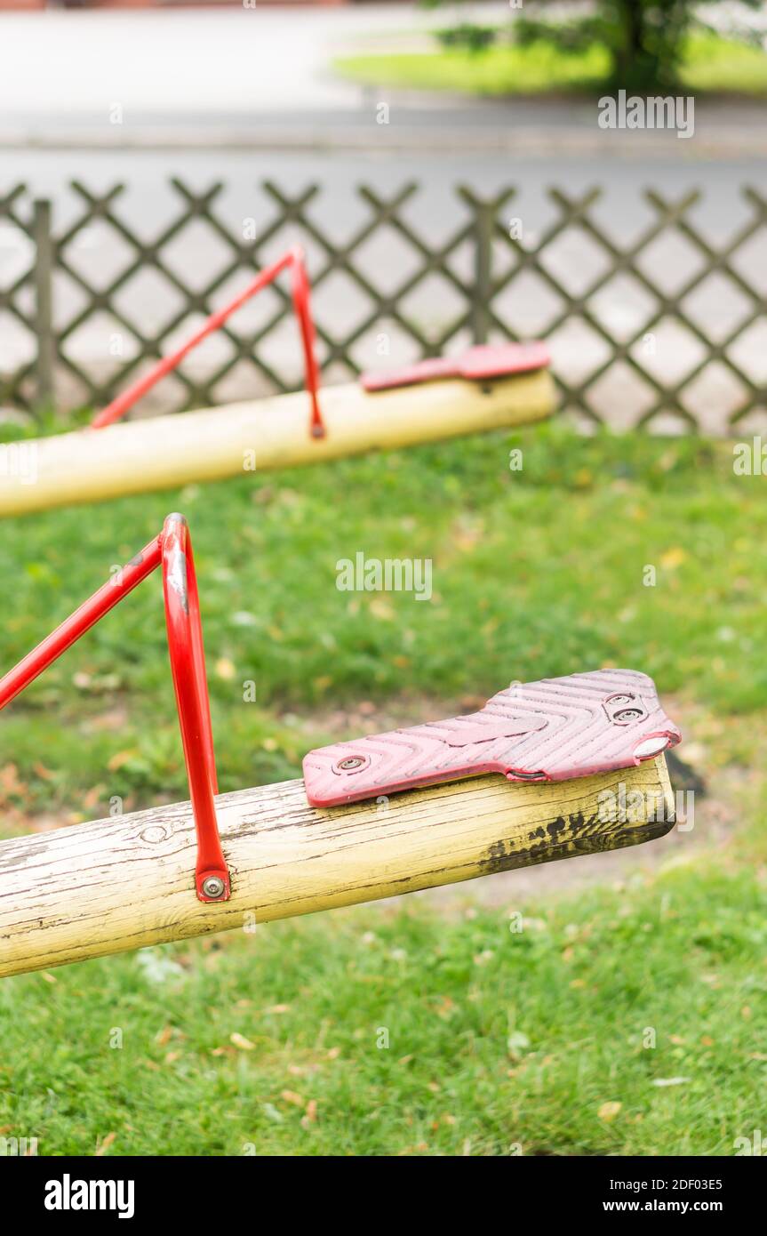 A vertical closeup focus shot of a seesaw with a red handle on a ...