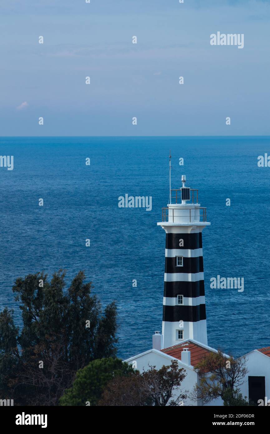 A vertical of black and white lighthouse on background of a boundless ...