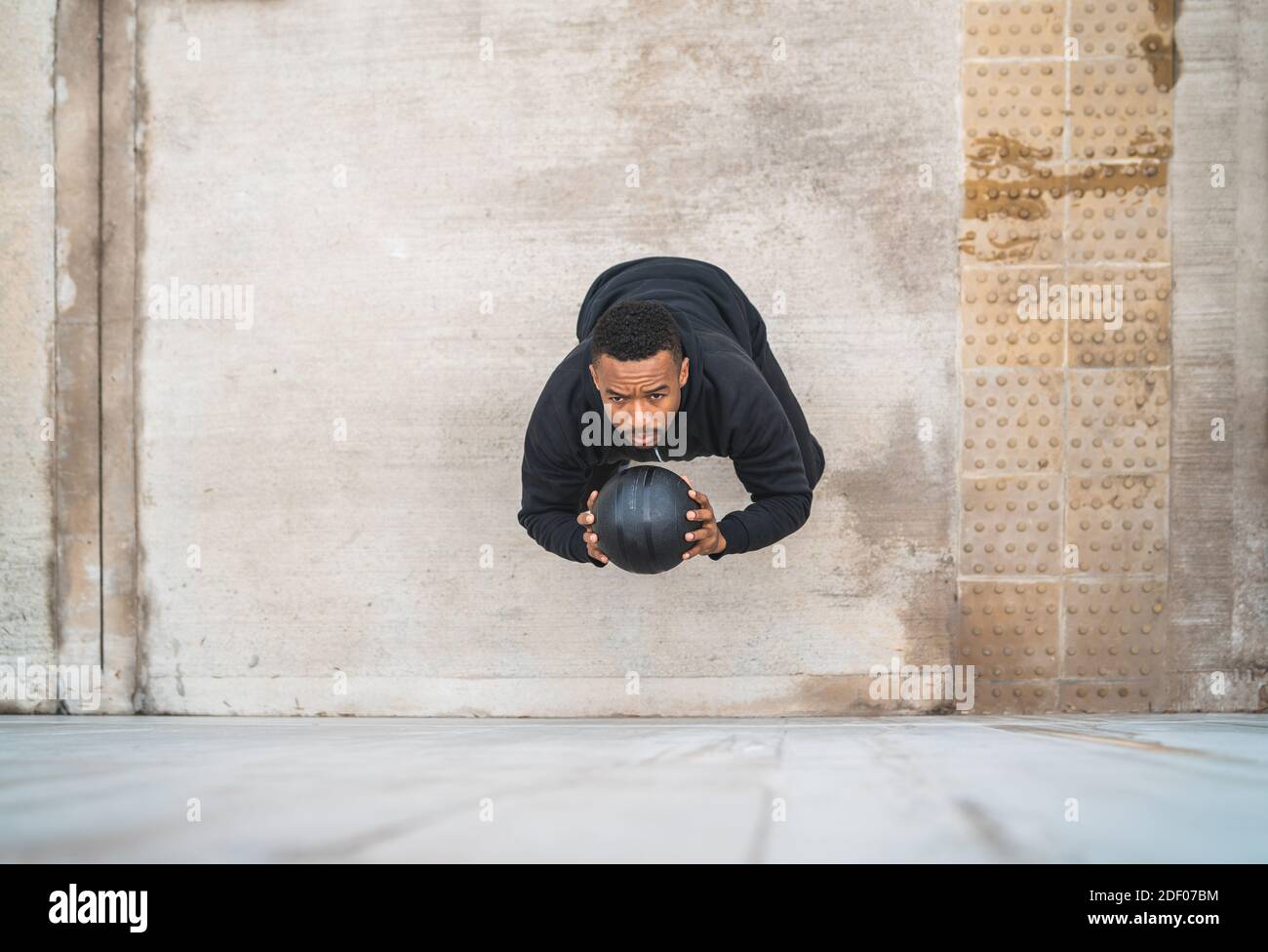 Athletic man doing wall ball exercise Stock Photo - Alamy
