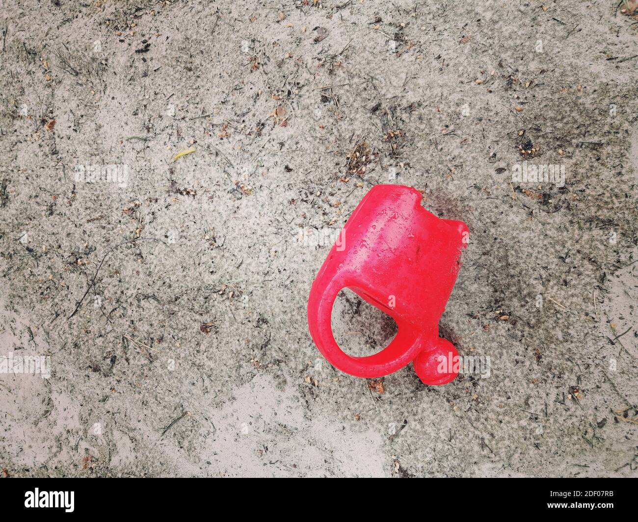 Red plastic toy laying on sand Stock Photo - Alamy