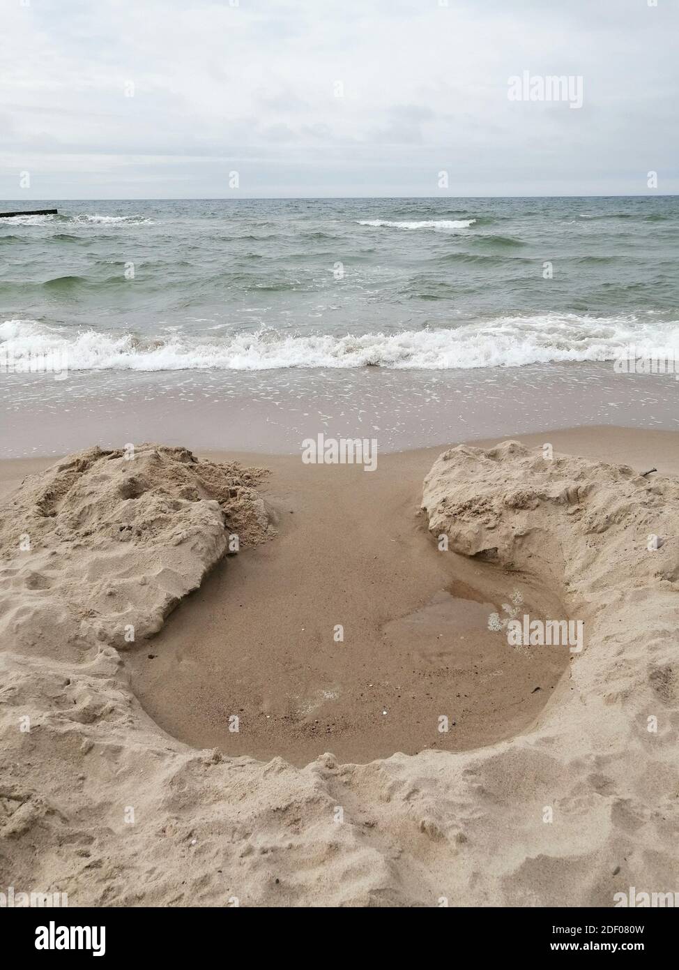 A vertical shot of a small bunker for the water made of sand at the ...