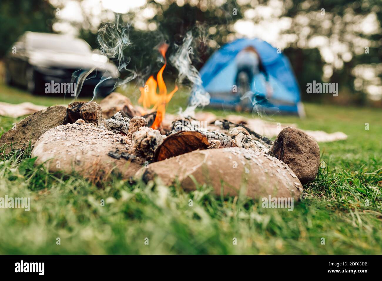 Campfire and tent with a car on its background Stock Photo - Alamy