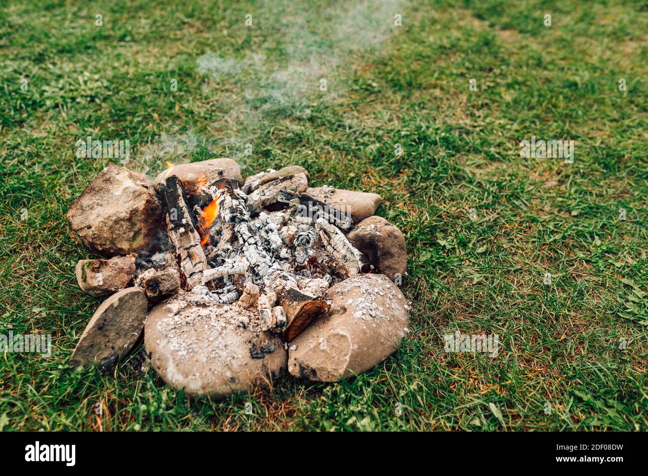 Burning camping bonfire on grass background Stock Photo - Alamy