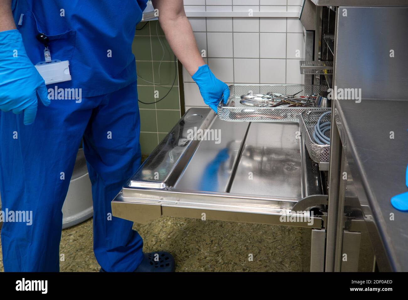 an employee of a surgical department loads a washing machine with used ...