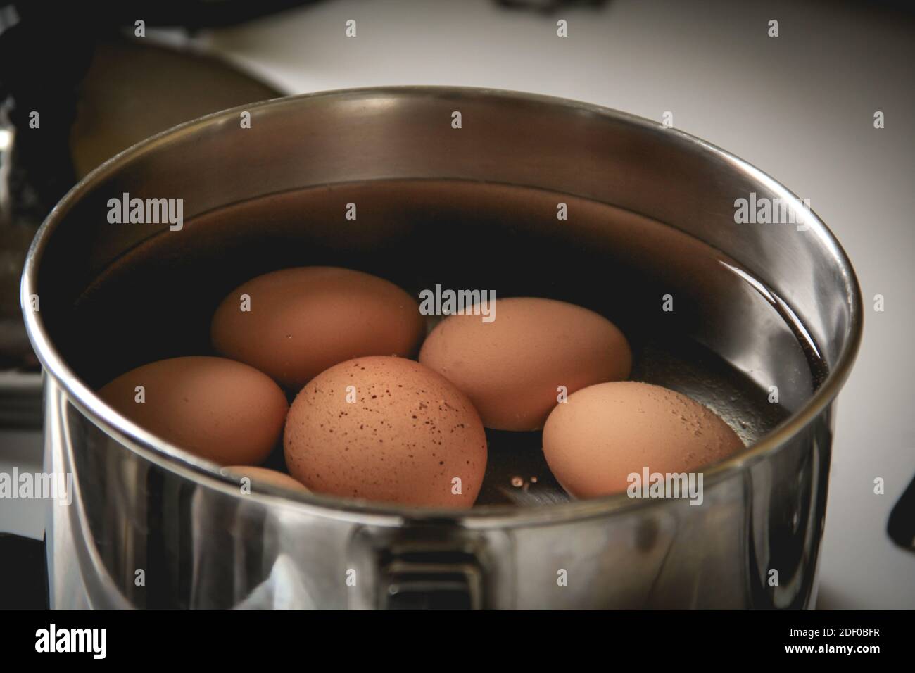 Brown eggs boiling in a small pot on the stove Stock Photo - Alamy