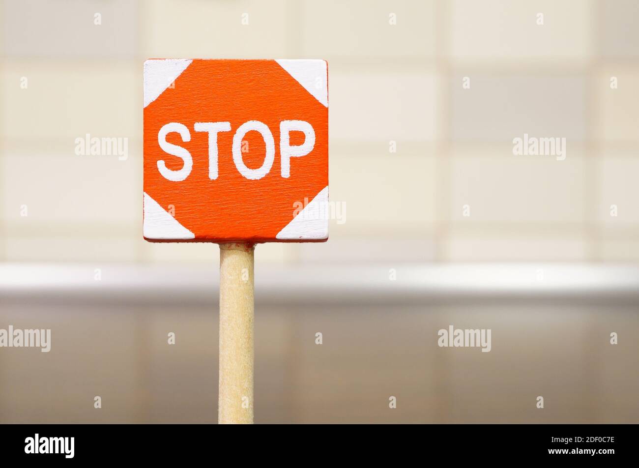 The red Stop sign in the street in front of a wall Stock Photo - Alamy