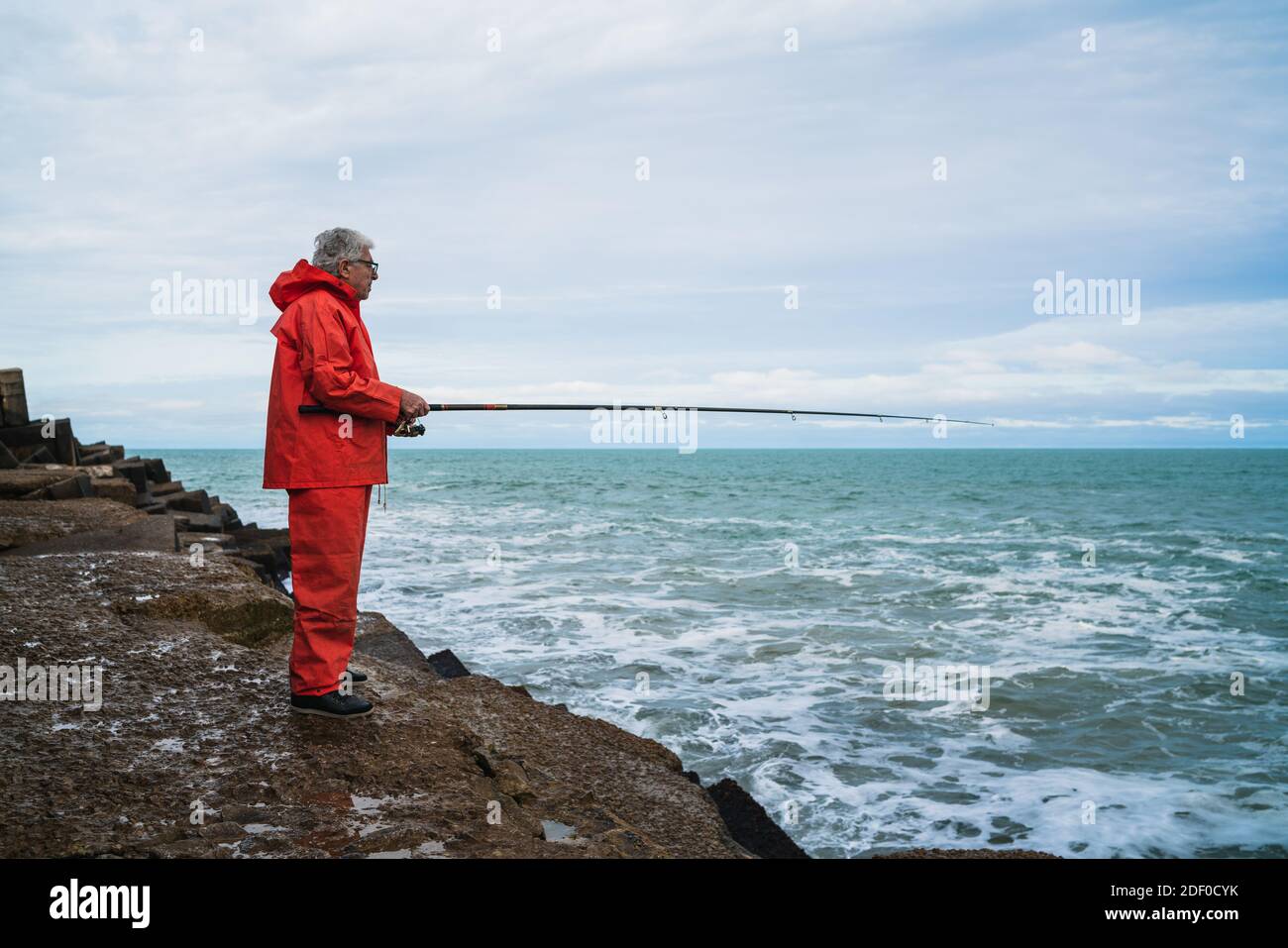 Old man fishing in the sea Stock Photo - Alamy