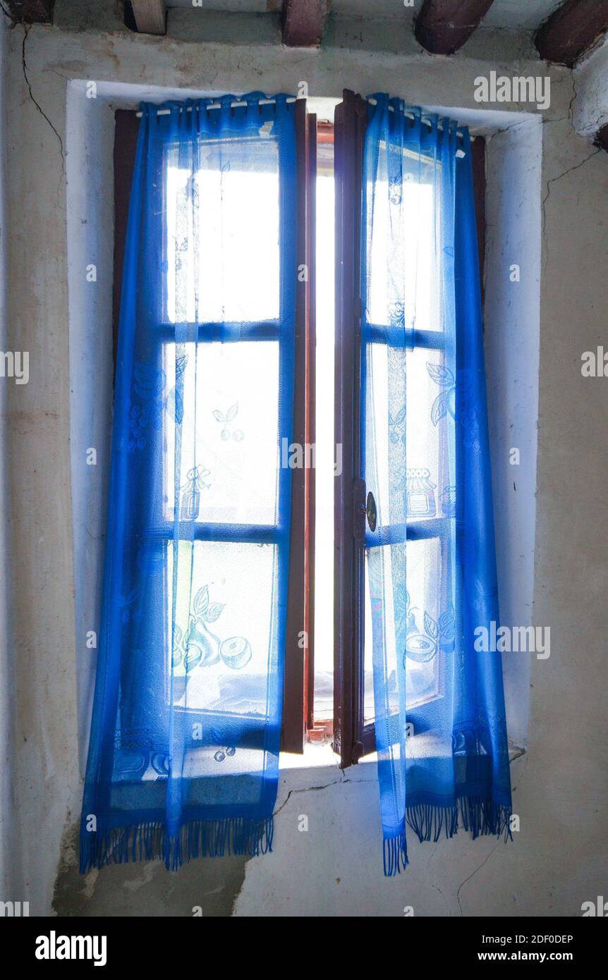 An half opened window with blue curtain on a concrete wall Stock Photo ...