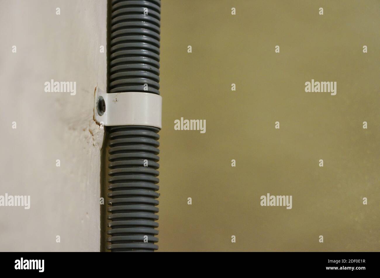 Plastic grey pipe attached to a wall in soft focus background Stock ...
