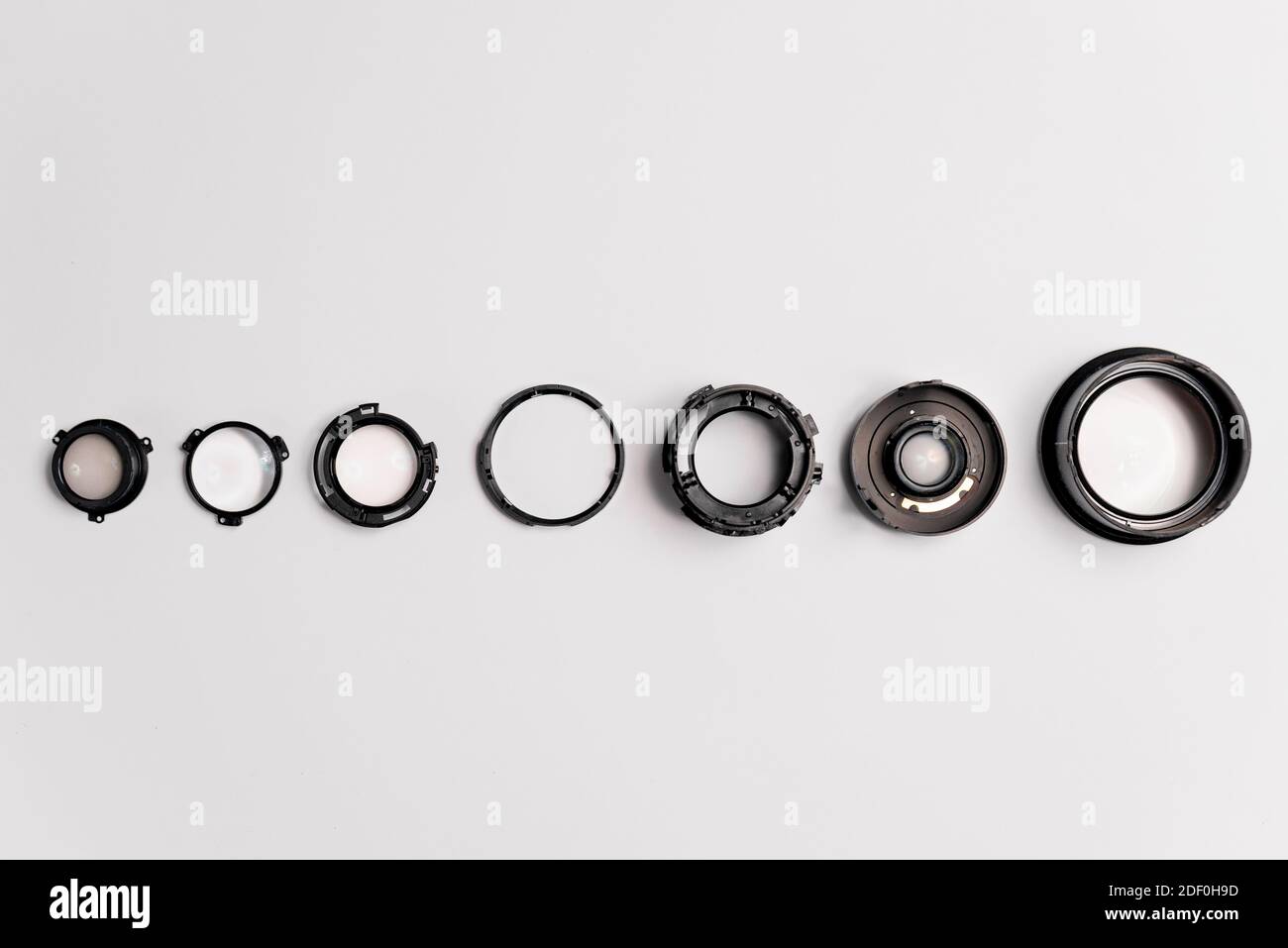 camera lens disassembled. elements and pieces of lens glass lay on ...