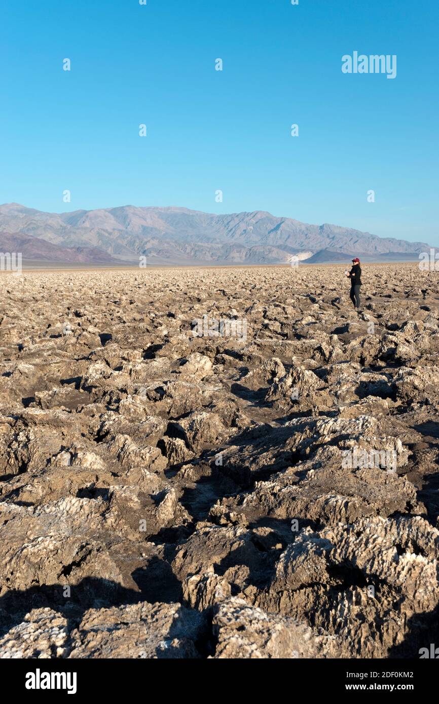 A tourist photographs the salt deposits at the Devil's Golf Course, a ...