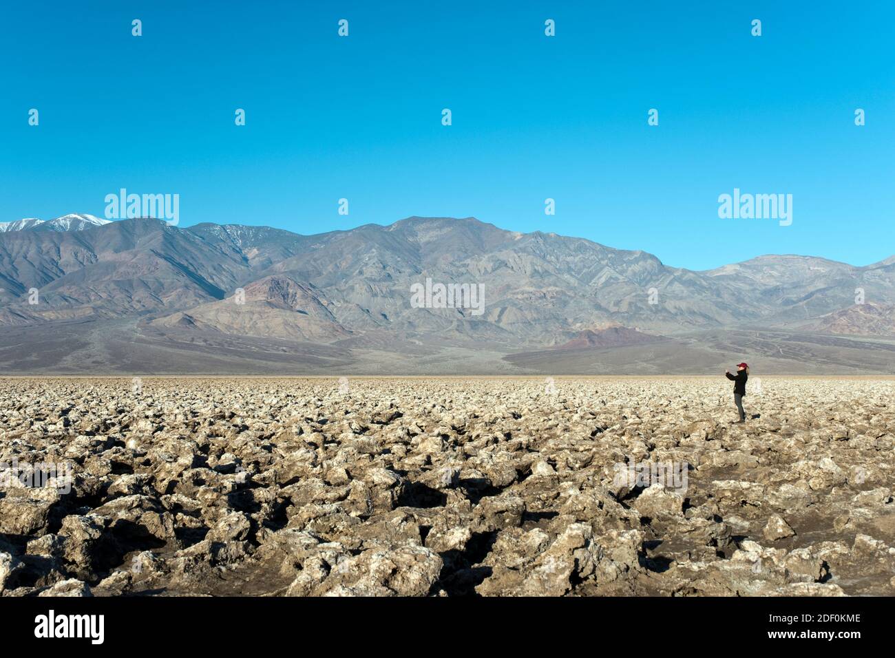 A tourist photographs the salt deposits at the Devil's Golf Course, a ...