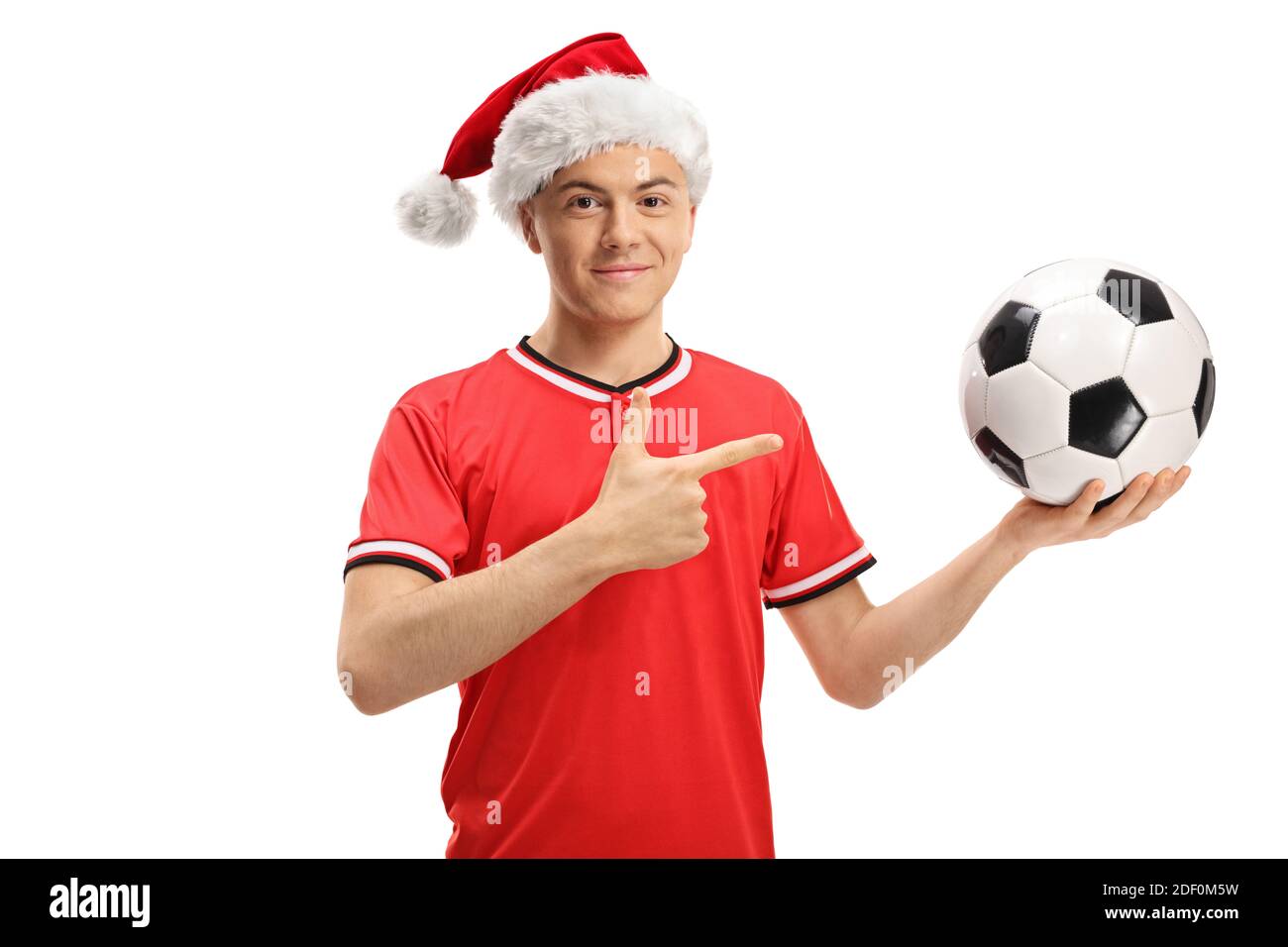 Young soccer player holding a football and wearing a santa claus hat ...