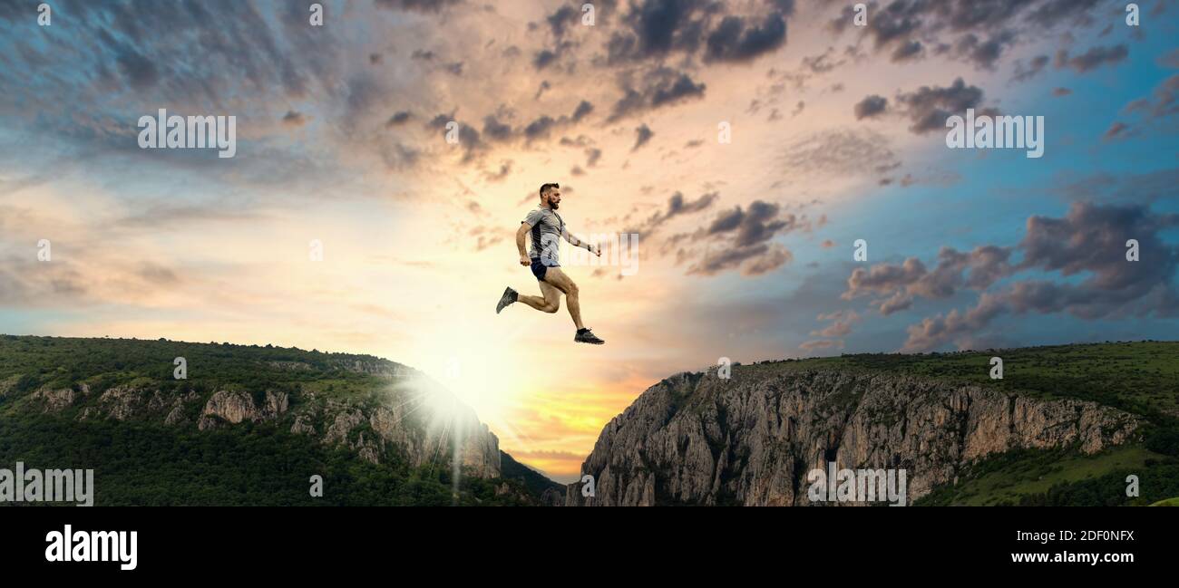 banner of man jumping between cliffs success concept Stock Photo - Alamy