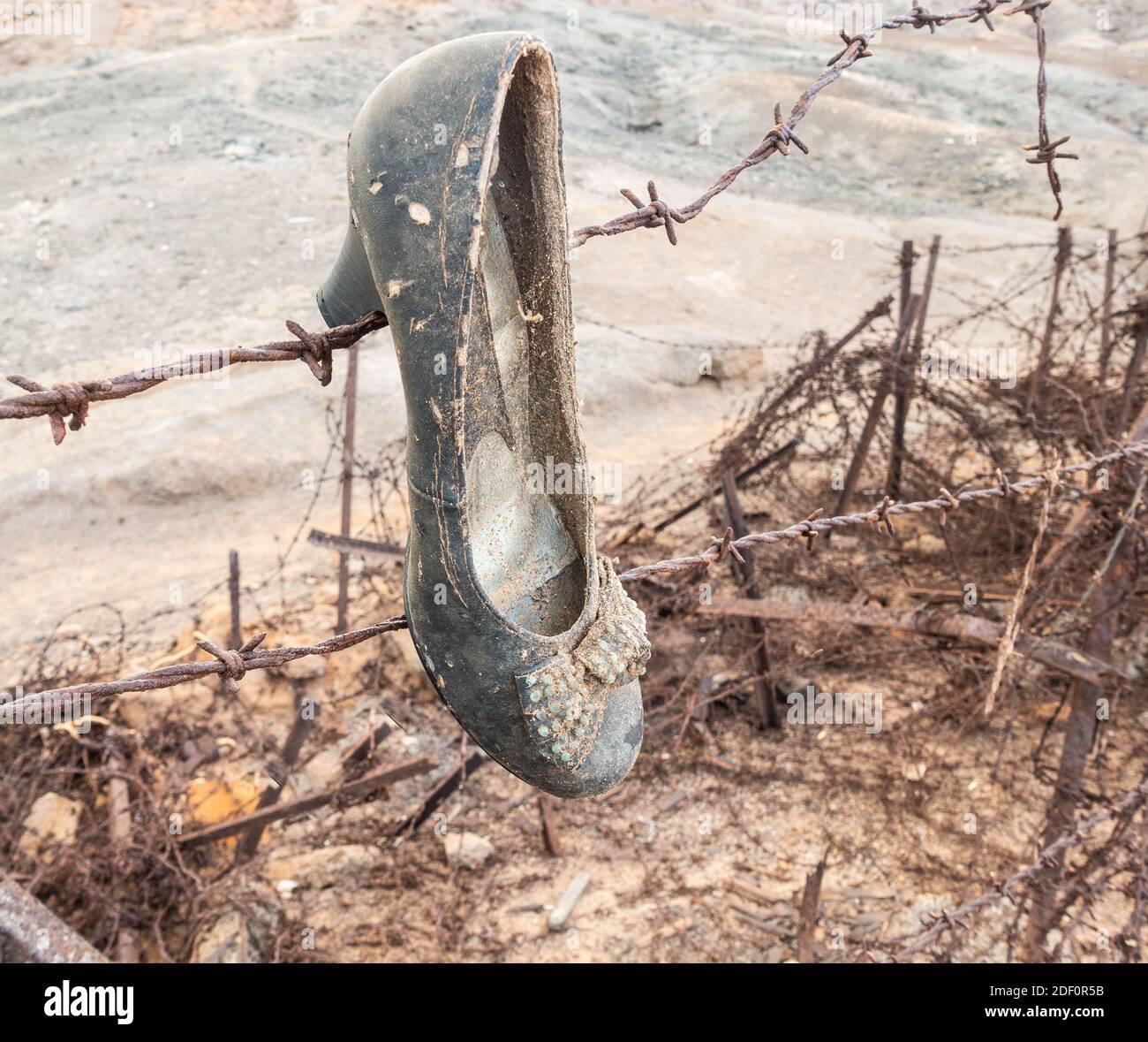 Womans shoe on barbed wire, razor wire fence Stock Photo - Alamy