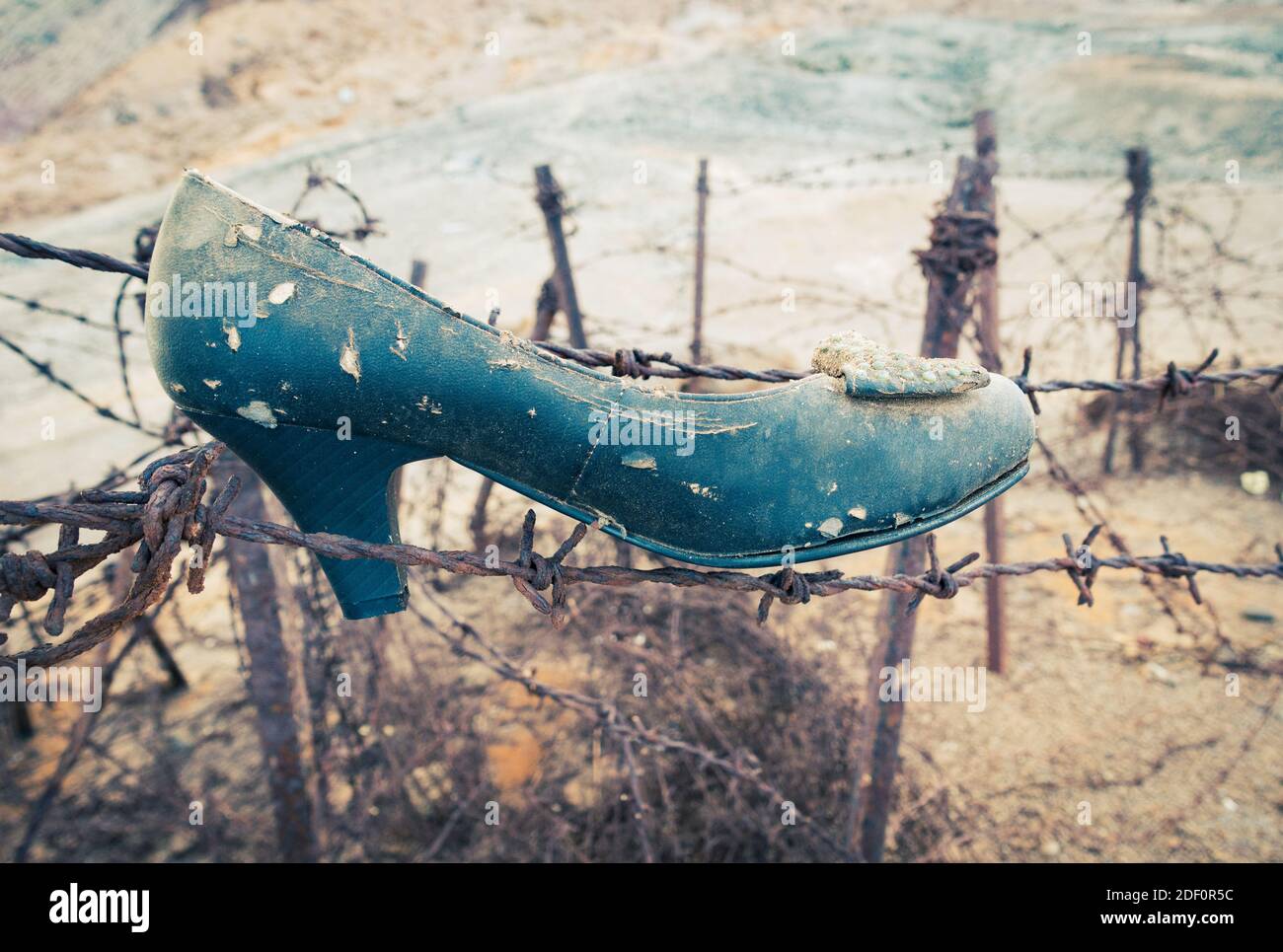 Womans shoe on barbed wire, razor wire fence Stock Photo - Alamy