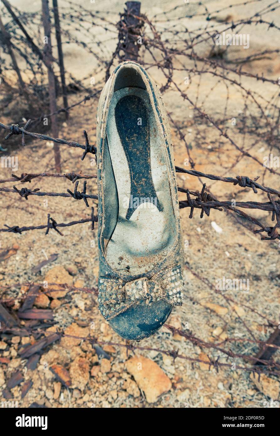 Womans shoe on barbed wire, razor wire fence Stock Photo - Alamy