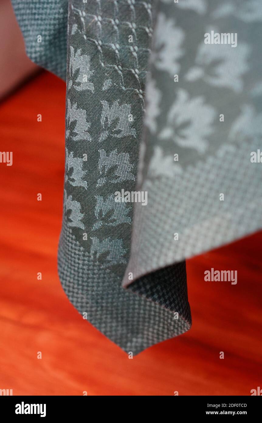 a closeup selective focus shot of a grey table cloth hanging on one ...