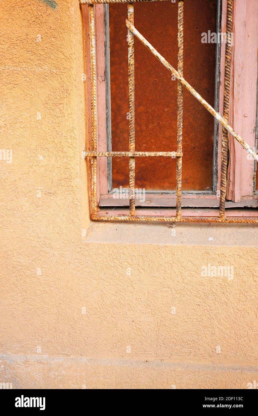 A vertical image of an old and rusted window bars Stock Photo - Alamy