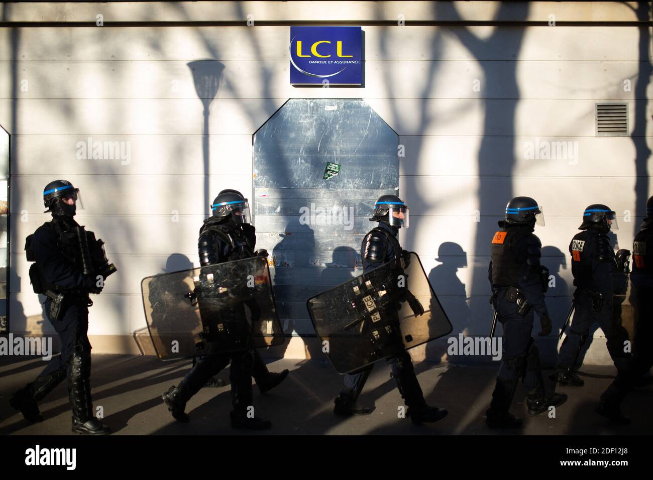Police forces walk in front of a LCL bank with metal barricades as a ...
