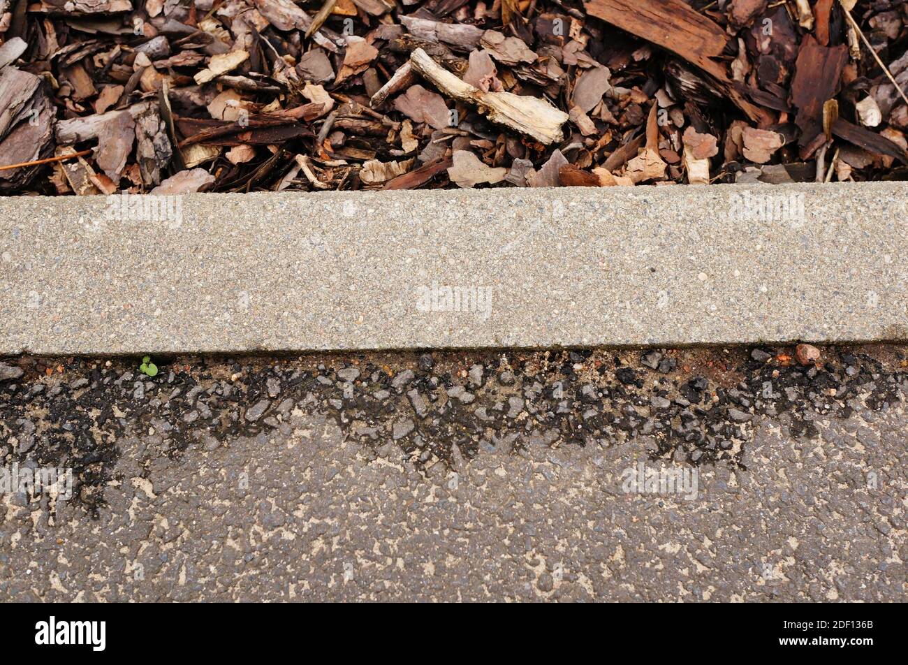 A top view shot of the edge of a concrete path with bark chips Stock ...