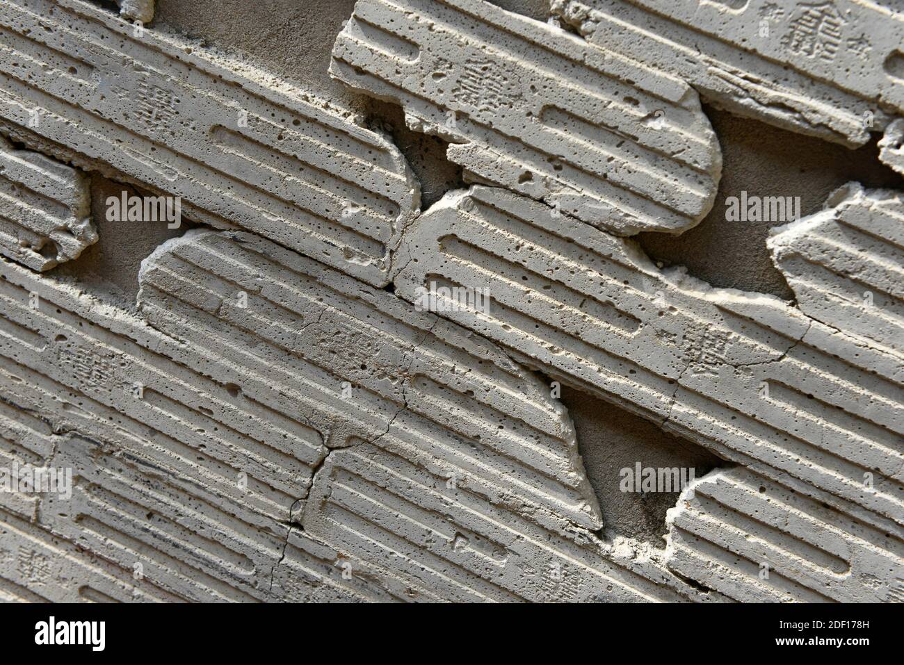 Cement blobs left on a wall after the tiles have been taken away ...