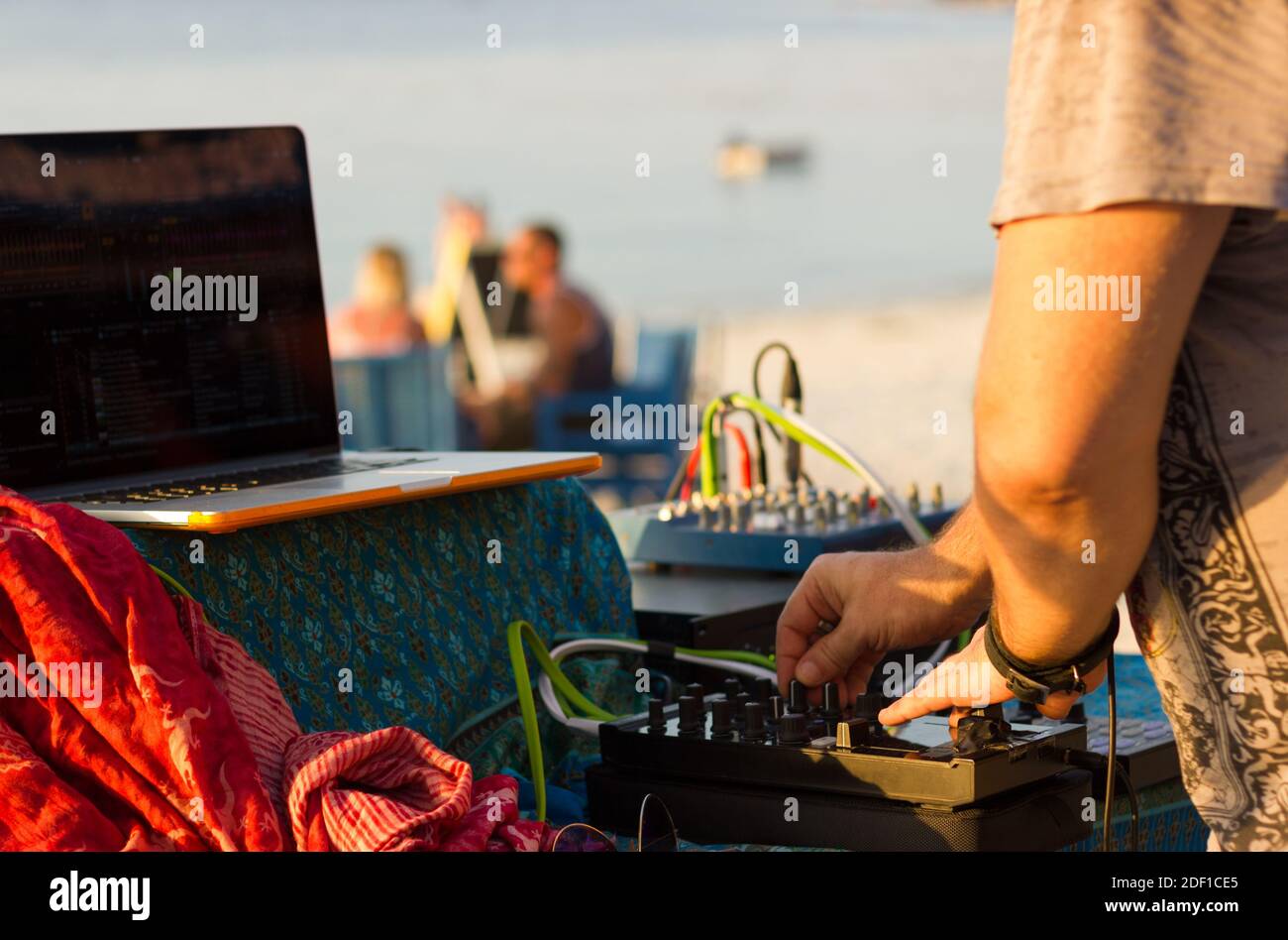 Disc jockey mixing music with his console and laptop on the beach at ...