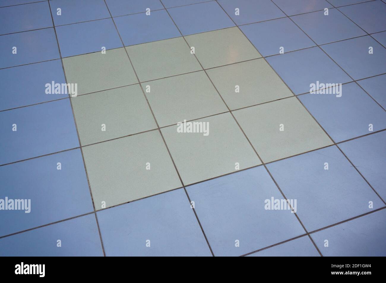 A top view shot of a floor with white tiles surrounded by blue tiles ...