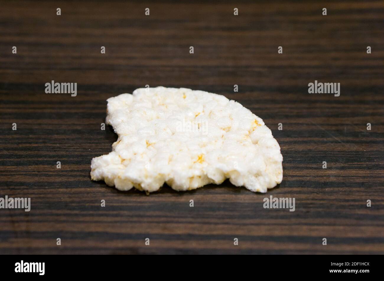 Piece of rice wafer laying on a wooden surface in soft focus background ...