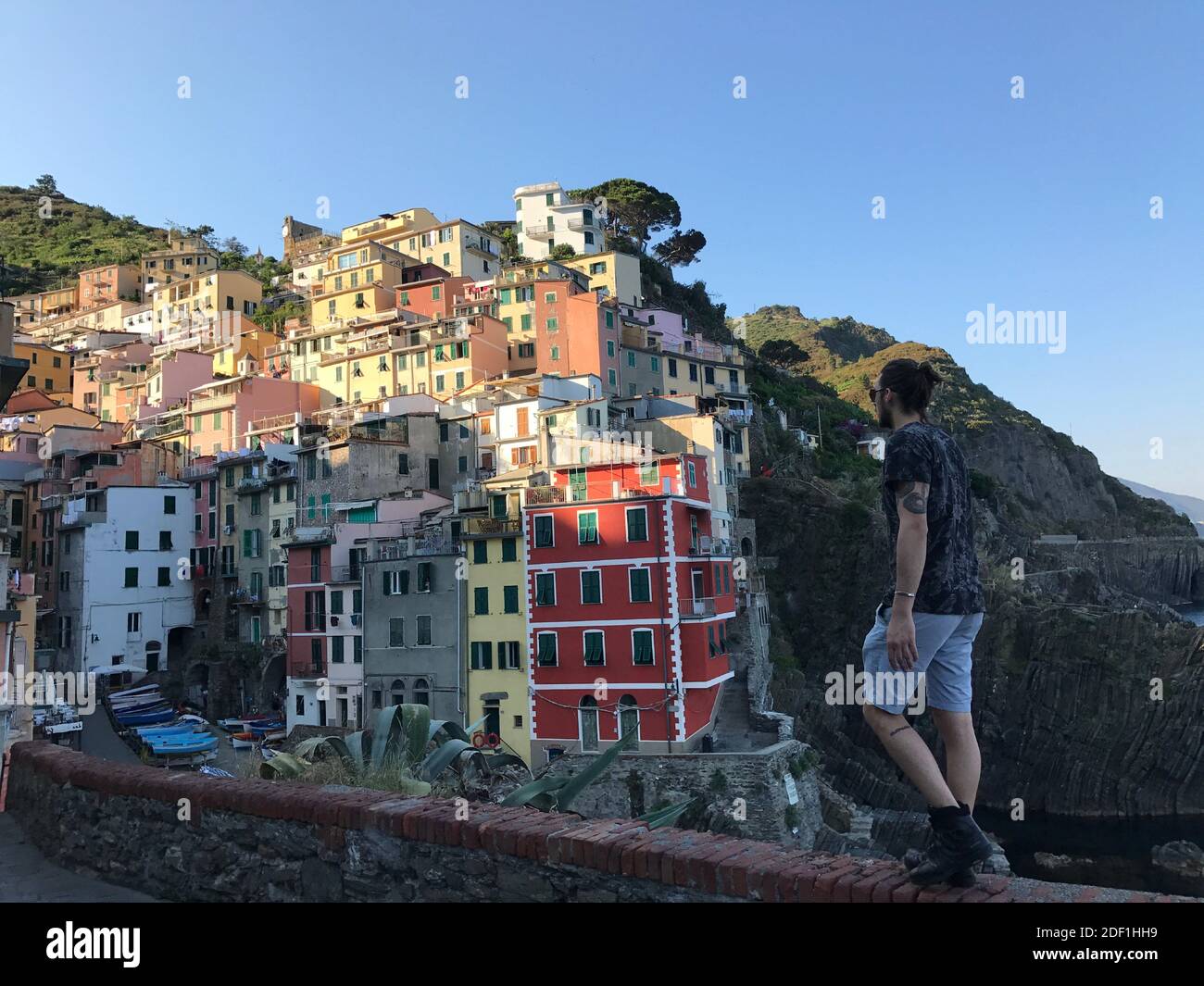 A young man walk and contemplates the beautiful Cinque Terre village ...