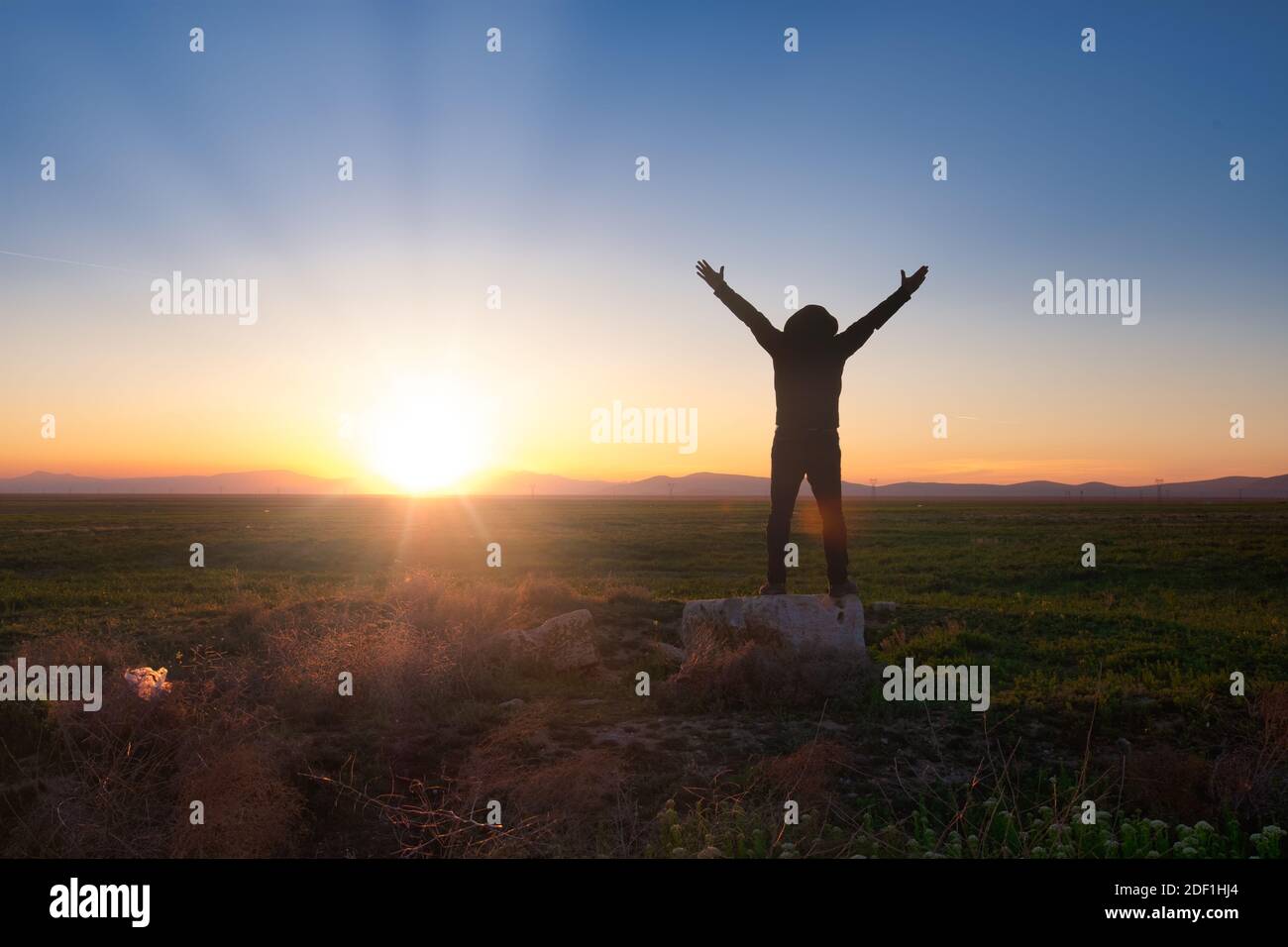 Man welcoming the sunrise with open arms Stock Photo - Alamy