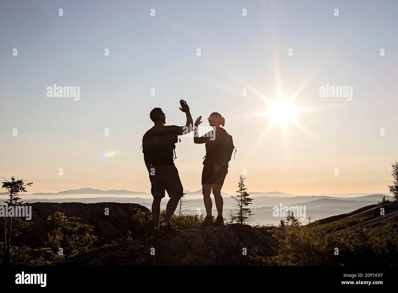 Two hikers high five and celebrate reaching summit of mountain, Maine ...
