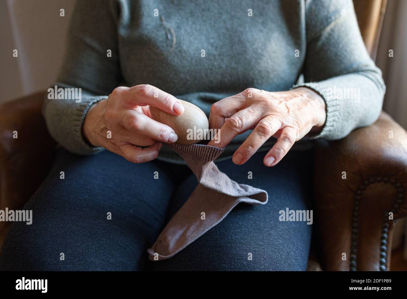 Old woman mending a sock at home Stock Photo - Alamy