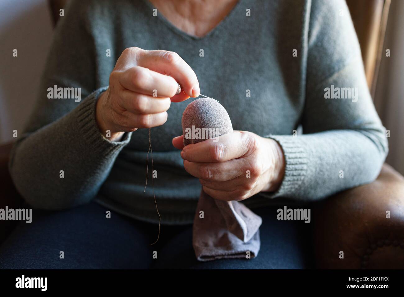 Old woman mending a sock at home Stock Photo - Alamy