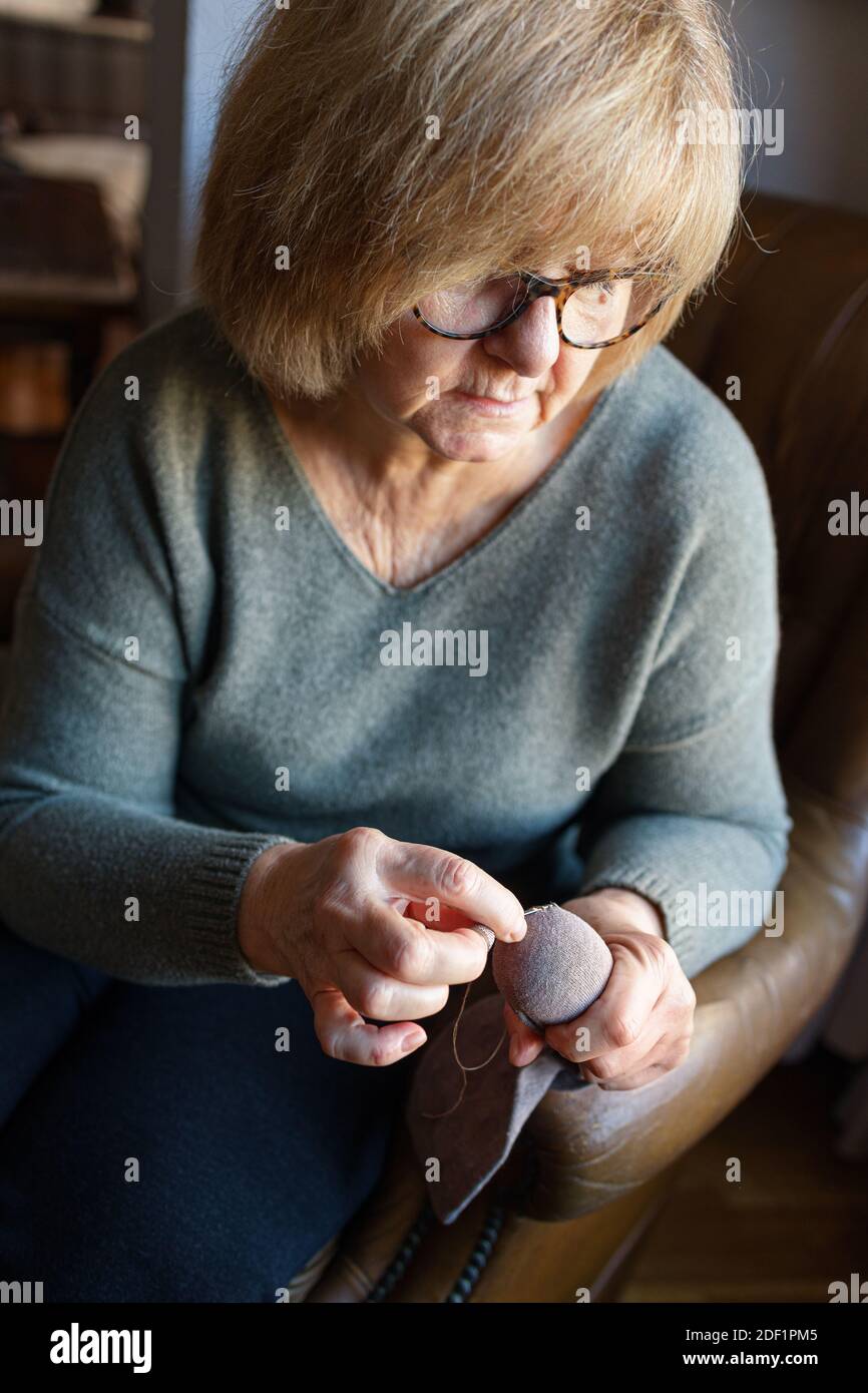 Old woman mending a sock at home Stock Photo - Alamy