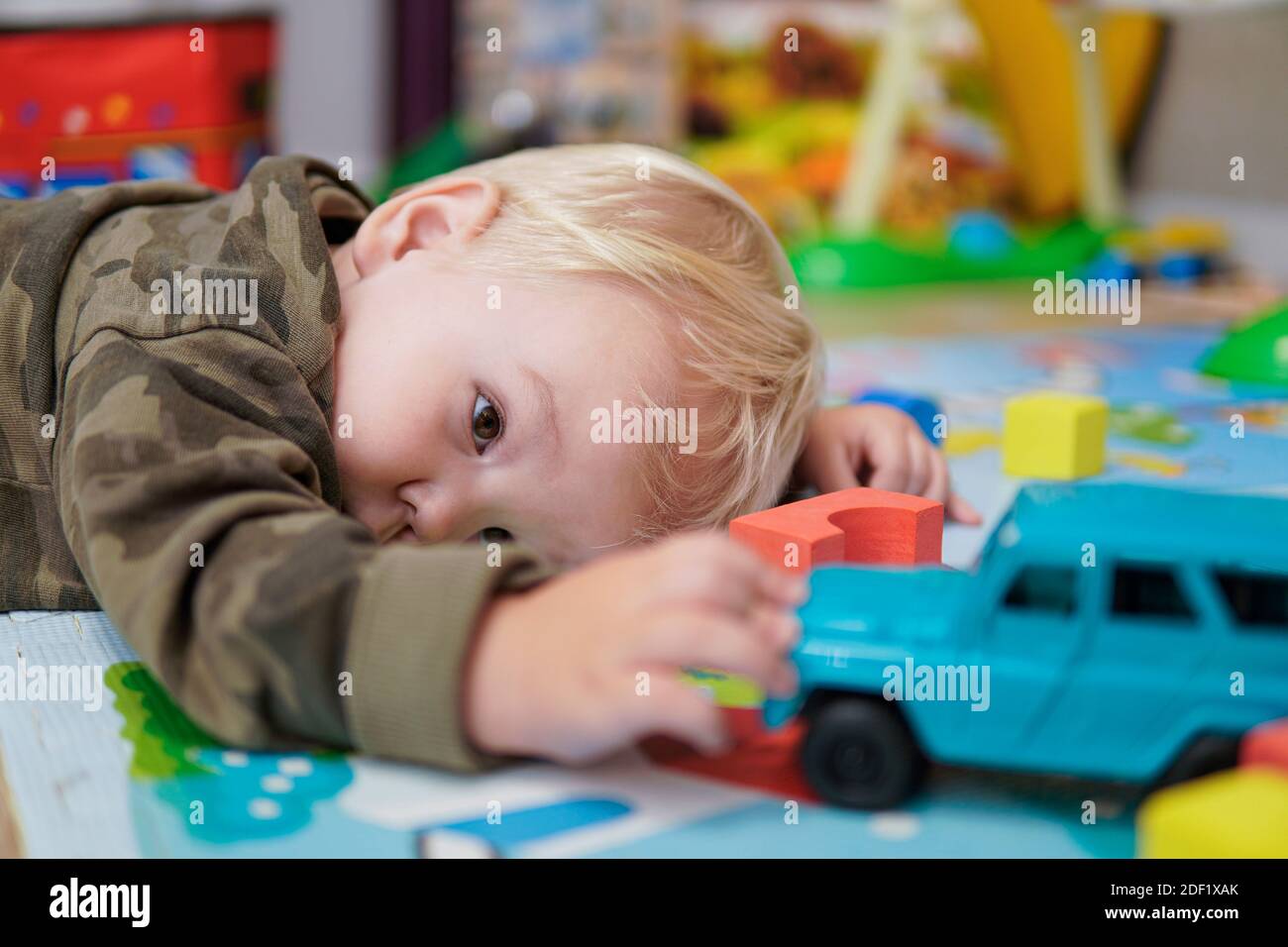 Little boy with blond hair playing with blue car. high quality Stock ...