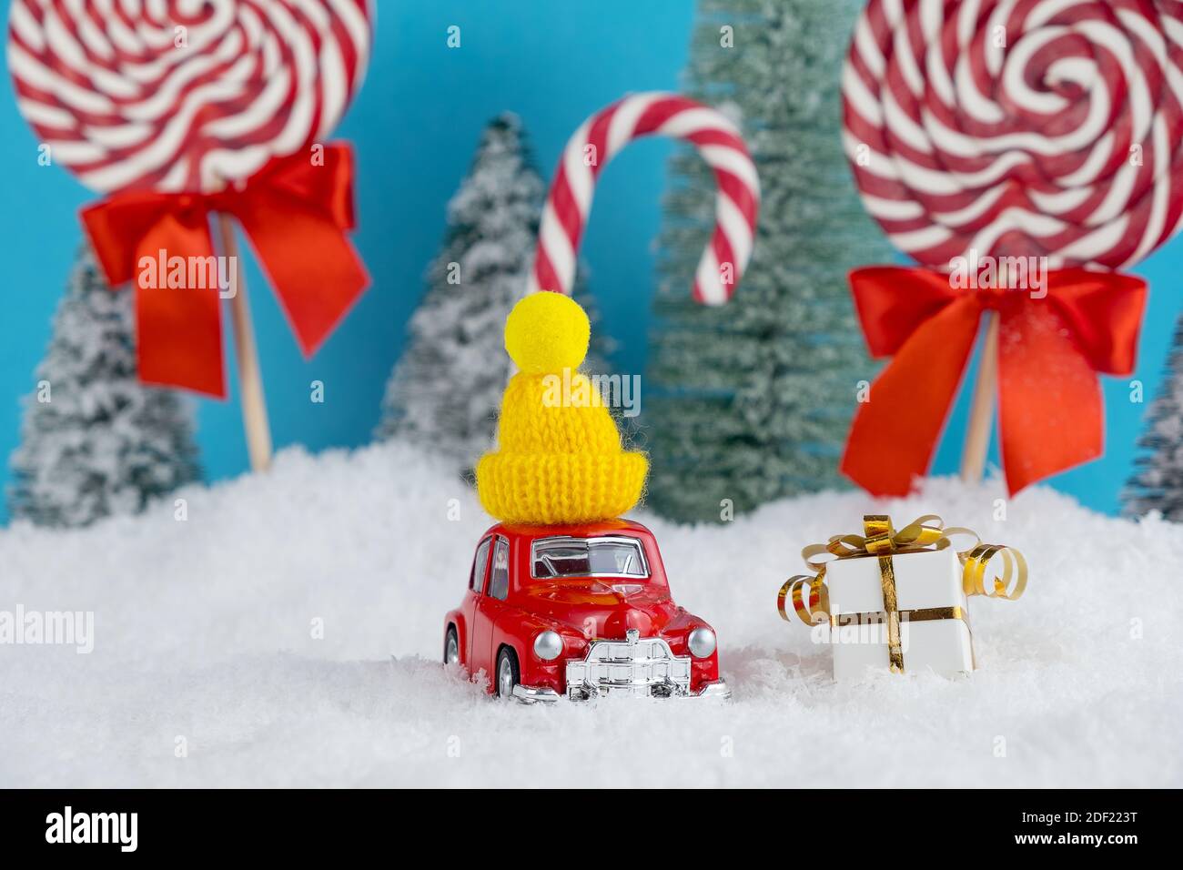 Red Santa car with gift boxes and Christmas tree in forest with candies ...