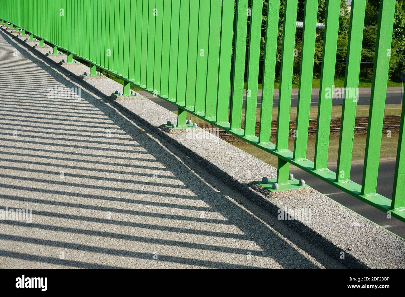 A closeup of the base of the green barrier of an overpass bridge Stock ...