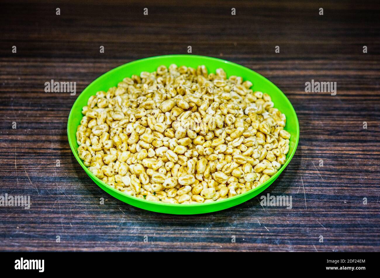 A closeup shot of puffed wheat cereals coated with honey in a green ...