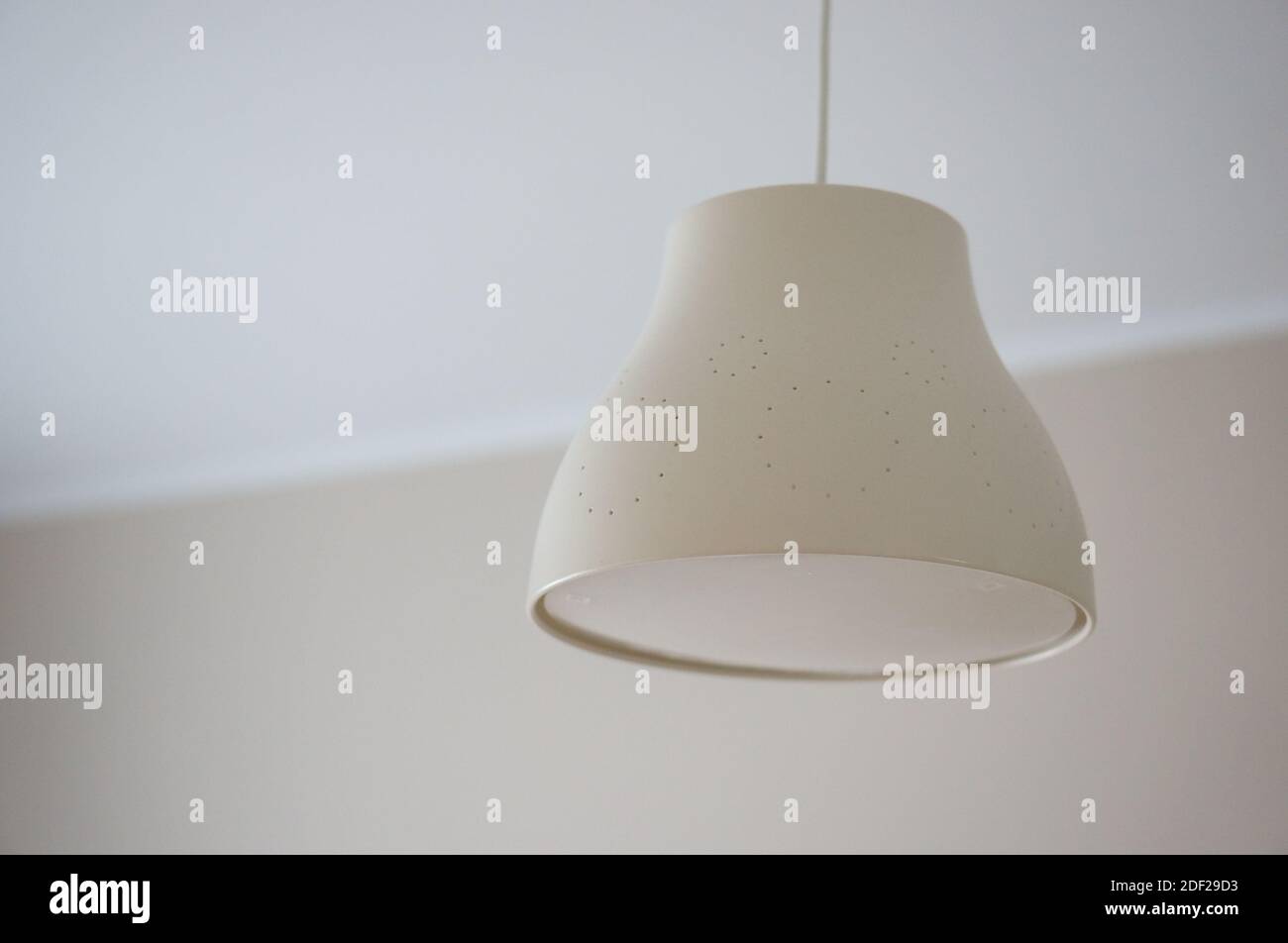 A white lamp hanging from a white ceiling Stock Photo - Alamy