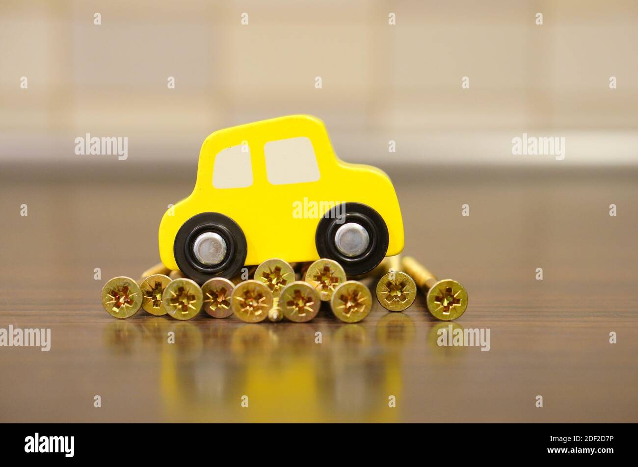 A yellow wooden toy car on golden screws Stock Photo - Alamy