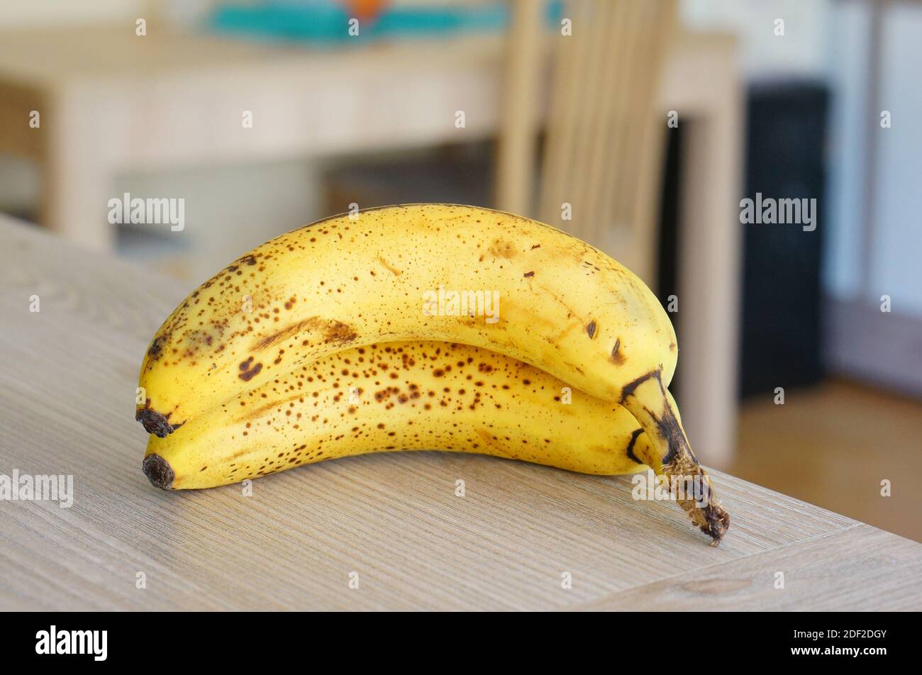 Two bananas on top of each other on the table Stock Photo - Alamy